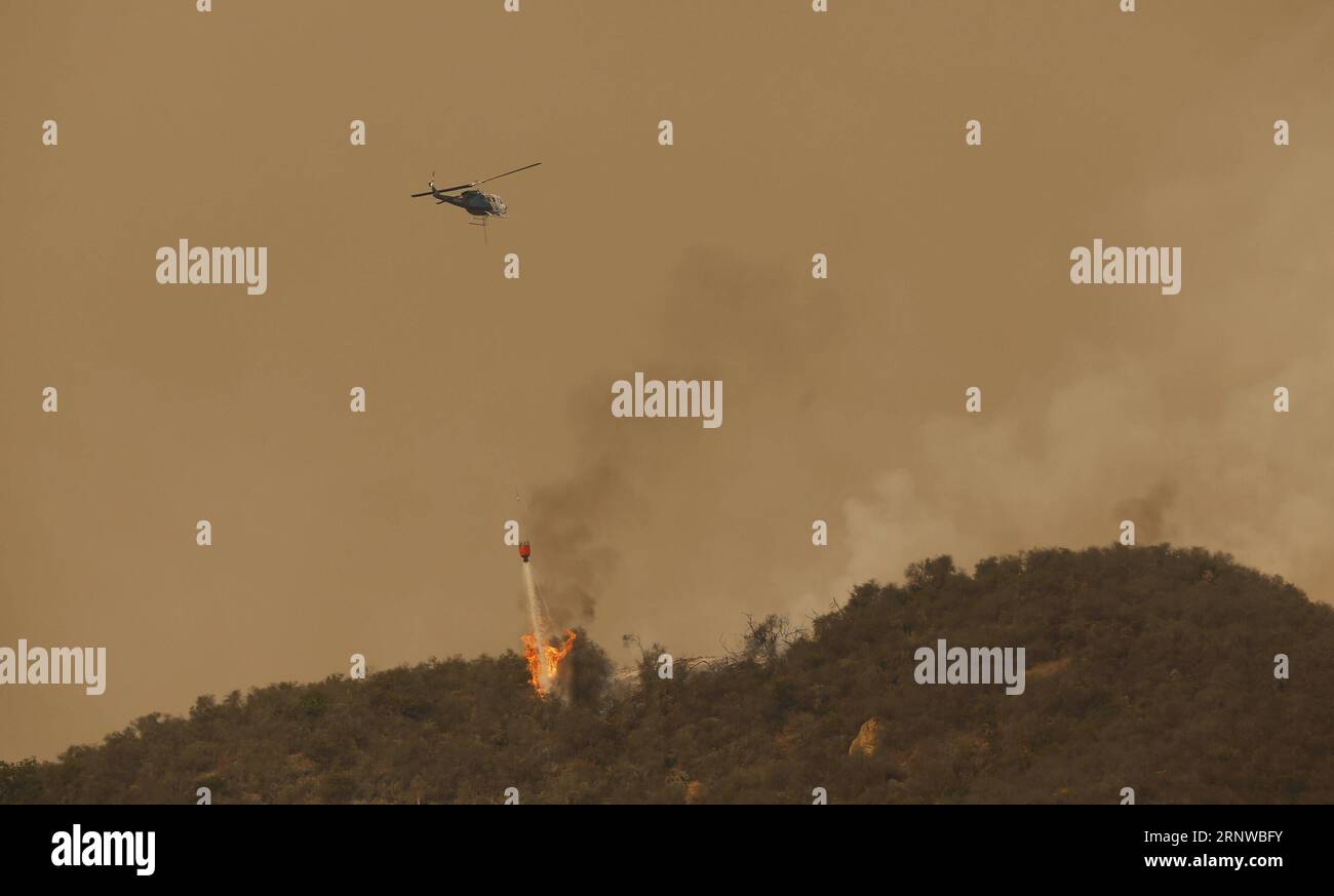 (171212) -- CARPINTERIA (US), Dec. 12, 2017 -- A helicopter sprays ...