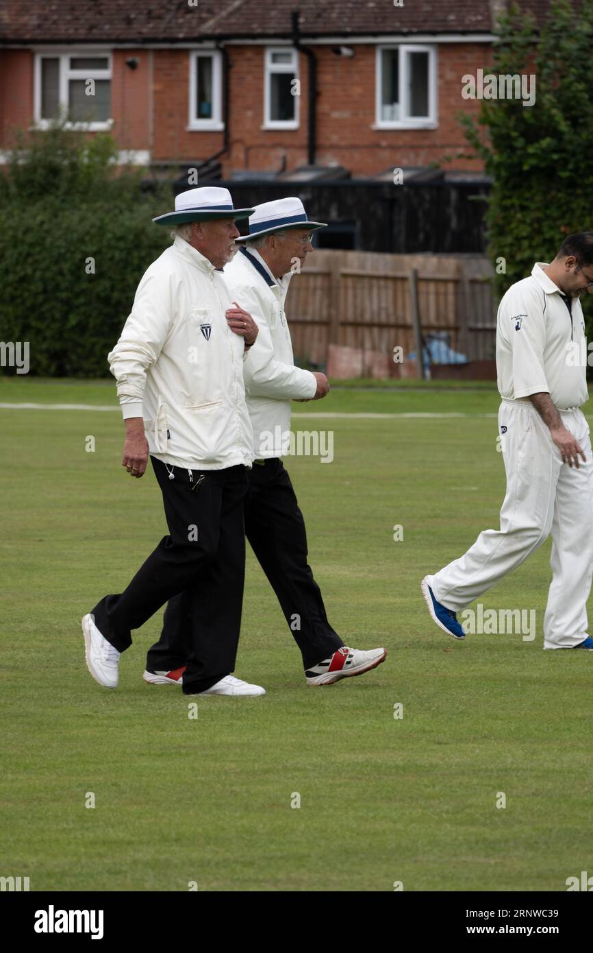 Two cricket umpires walking off the pitch Stock Photo - Alamy