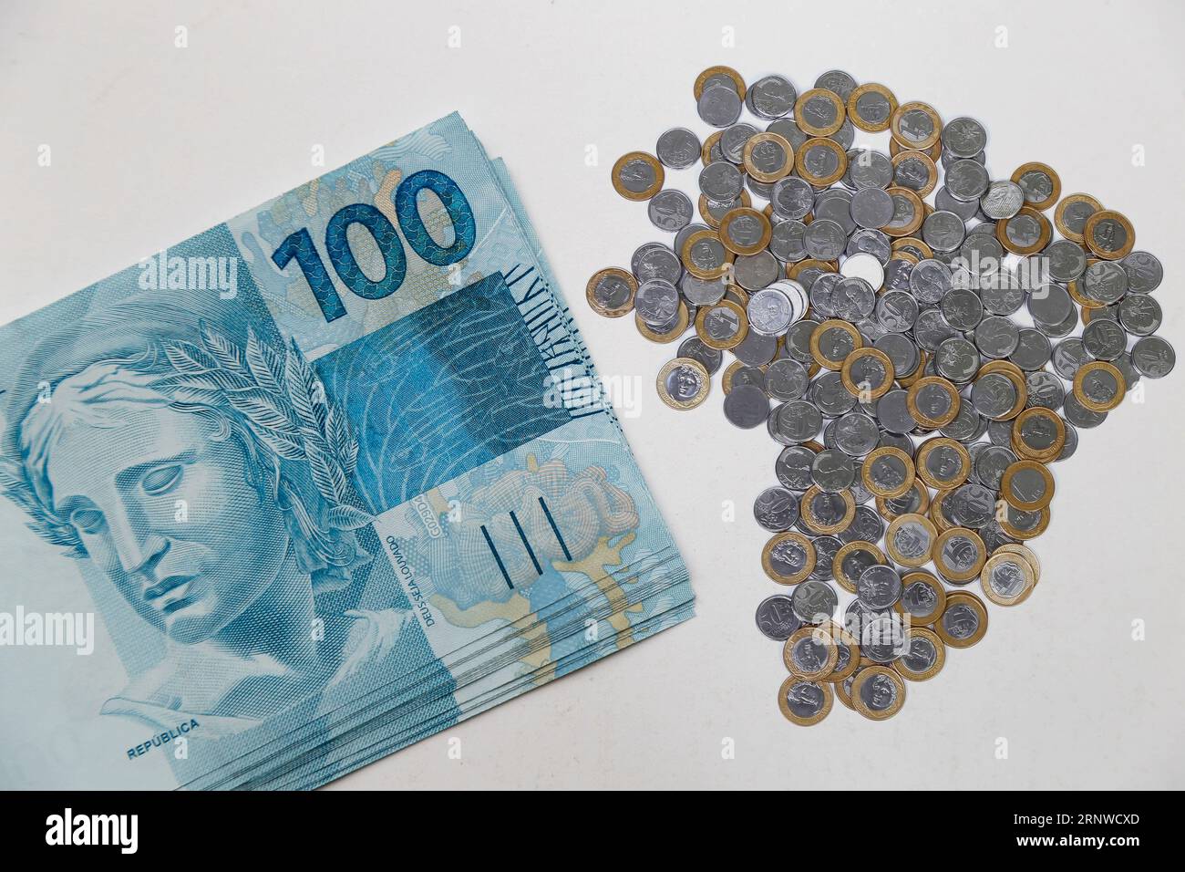 several hundred reais notes and coins from Brazil on neutral white ...
