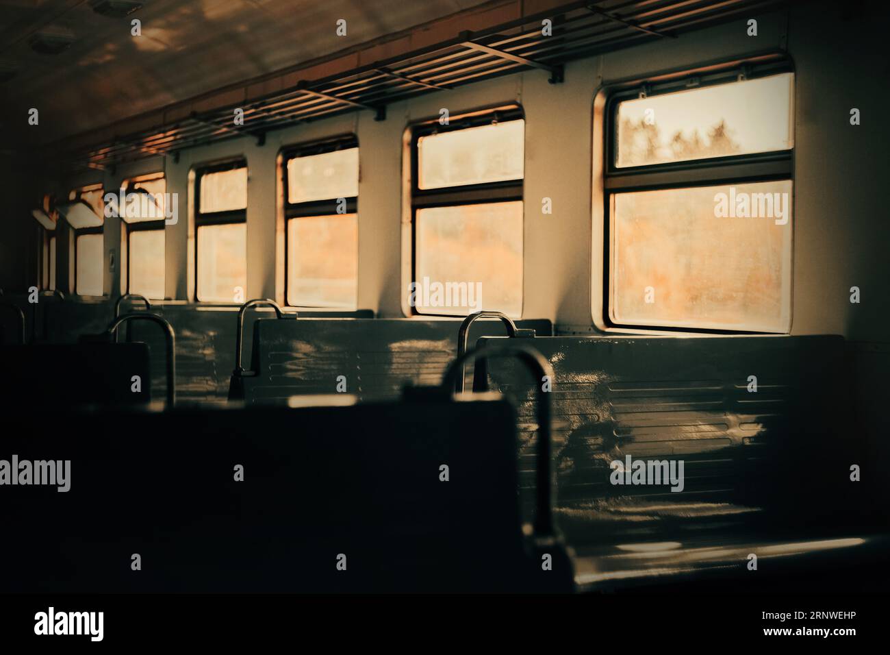 The empty interior of an electric train car, illuminated by rays of ...
