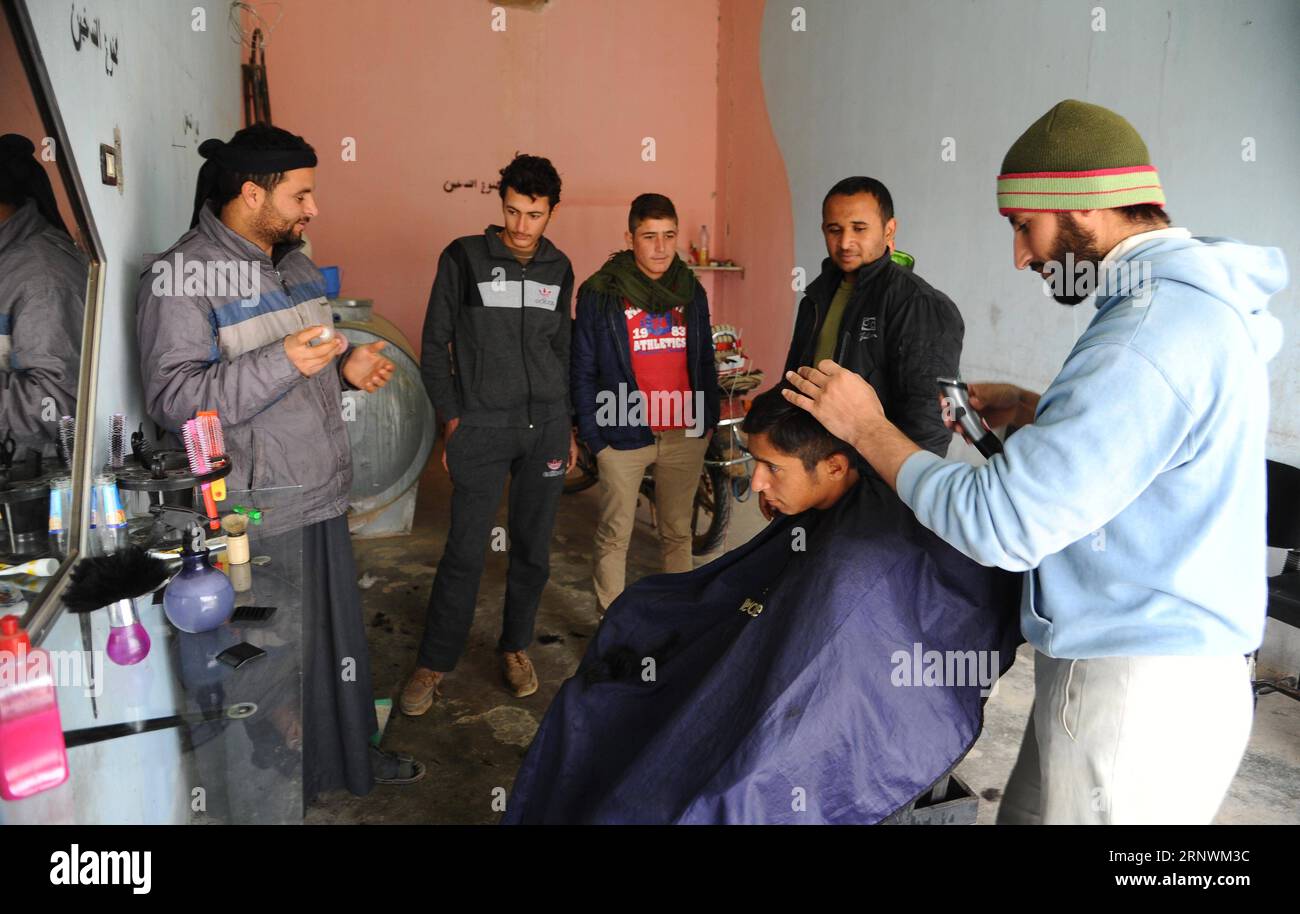 (171224) -- RAQQA, Dec. 24, 2017 -- A barber gives a haircut to a young ...