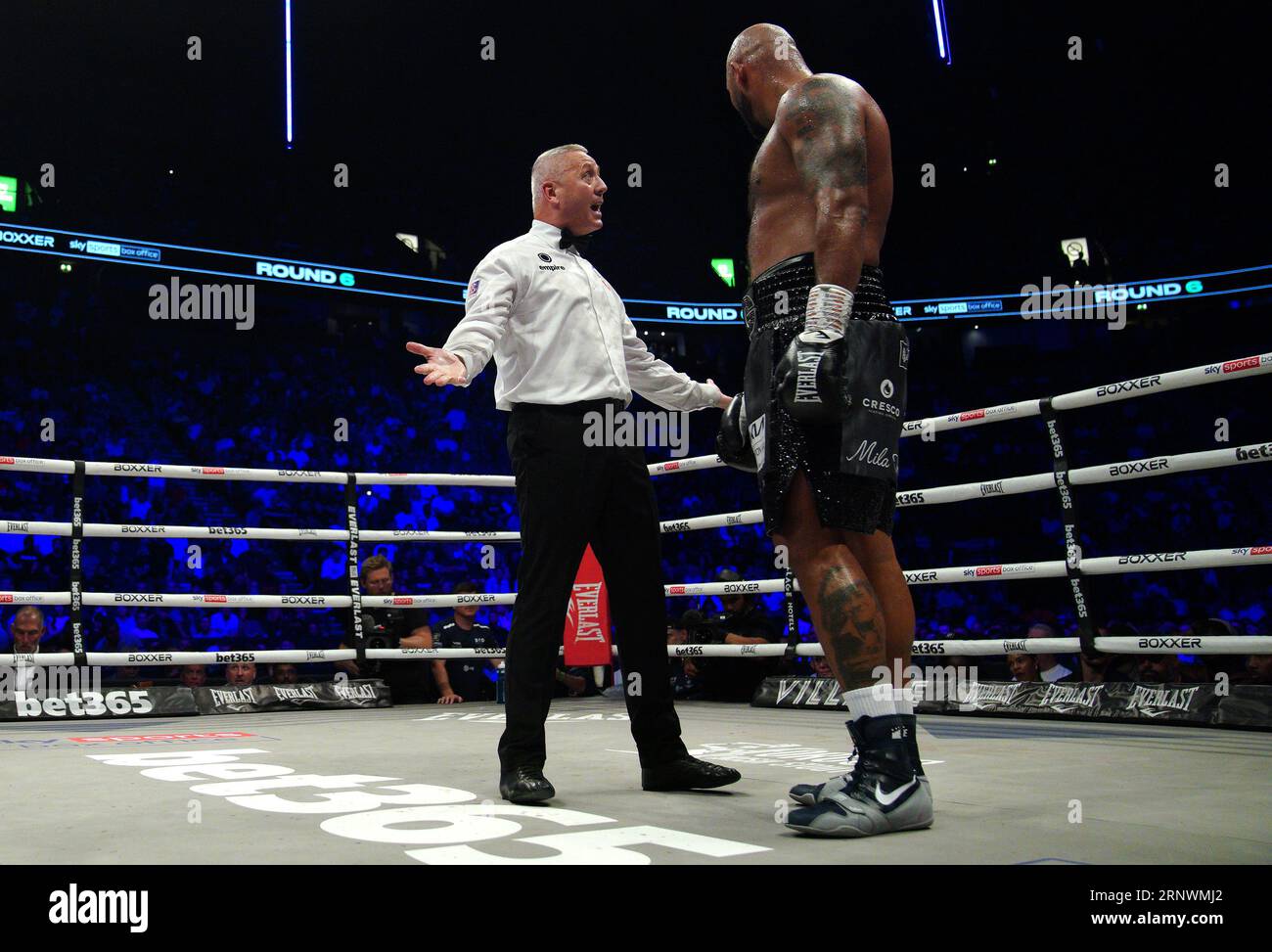Ring referee speaks to Frazer Clarke (right) after landing a low blow ...
