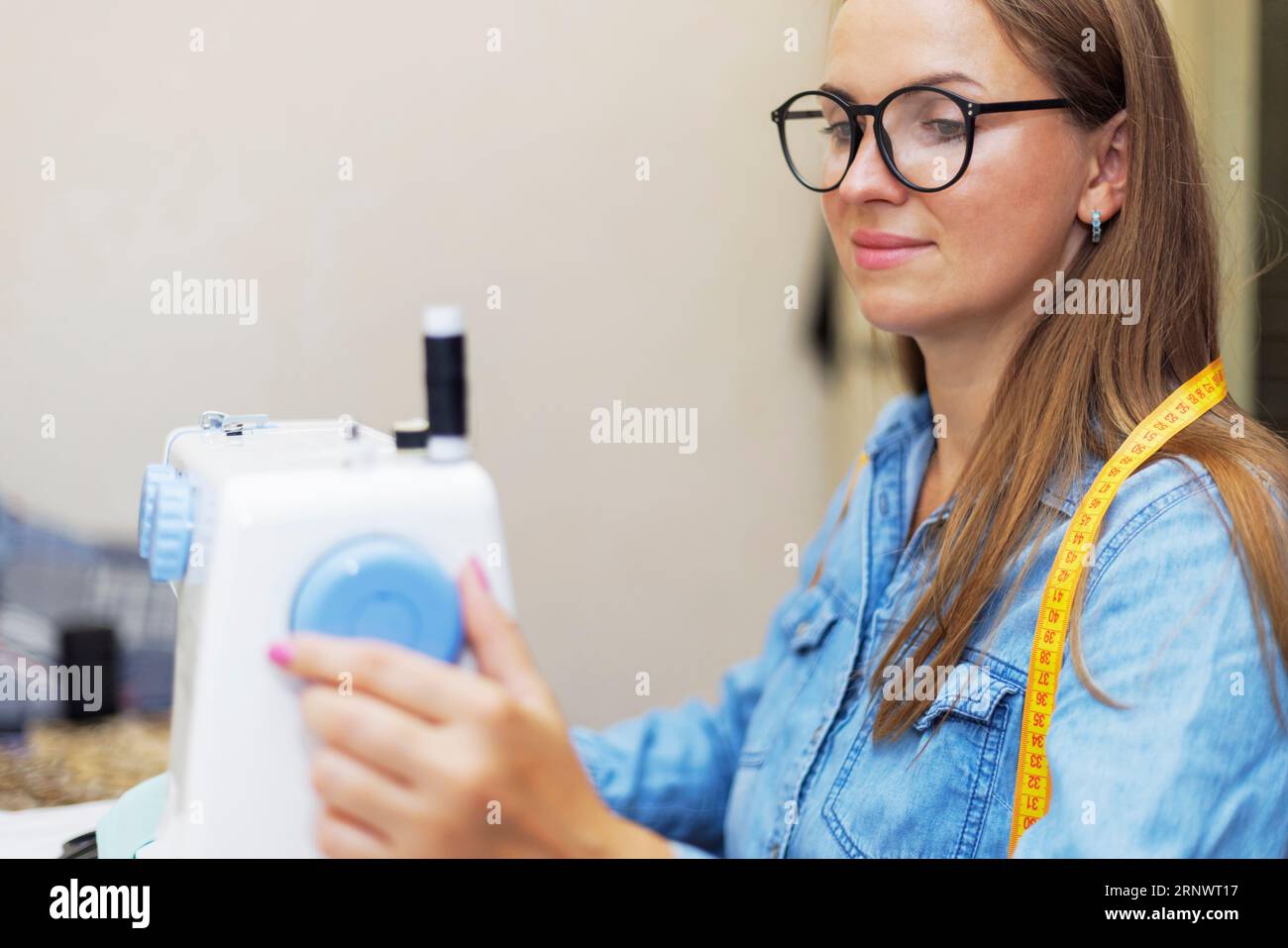 Beautiful young woman sewing clothes using a sewing machine Stock Photo ...