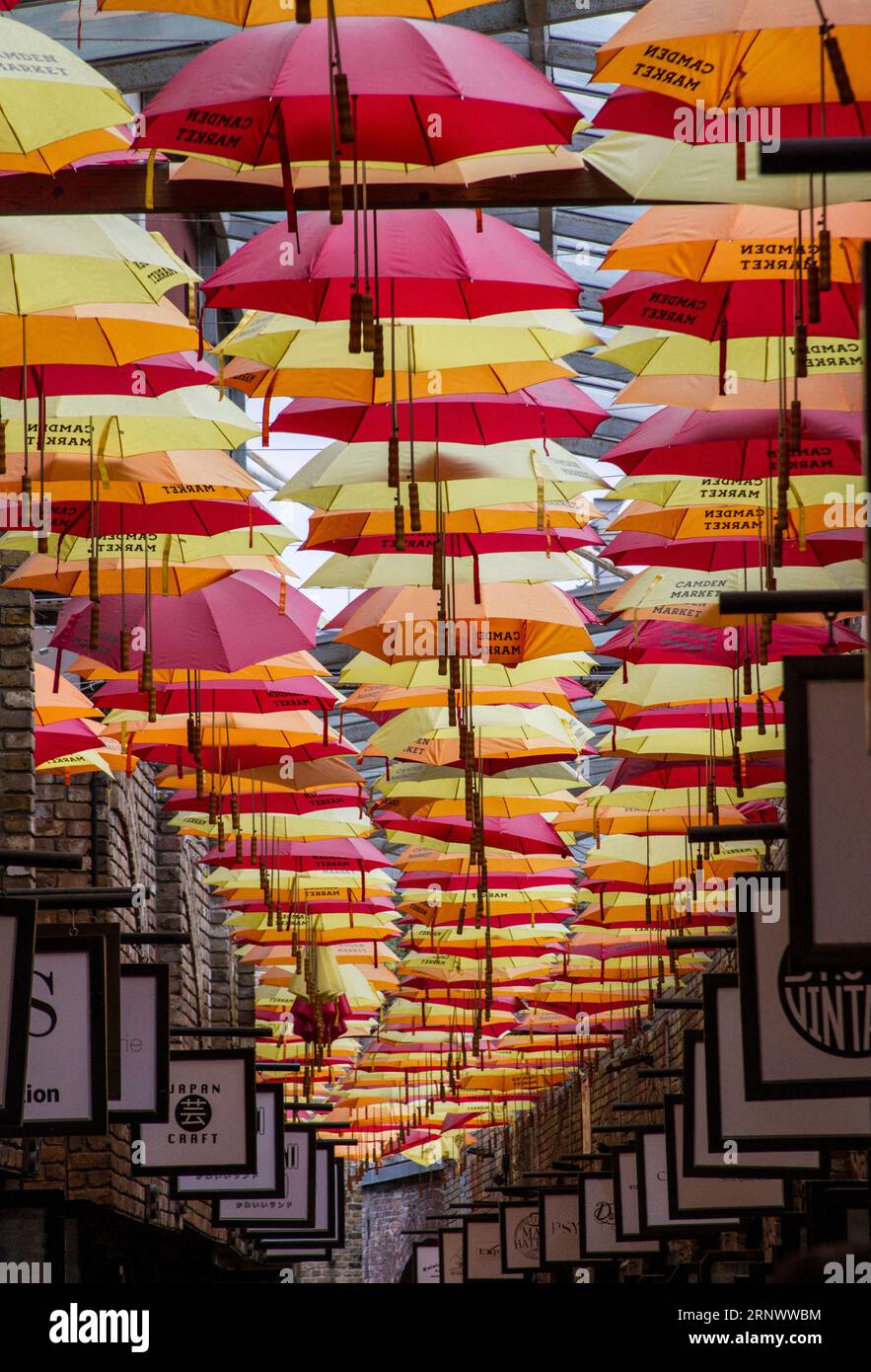 Street art red and yellow umbrellas suspended above an ally full of ...