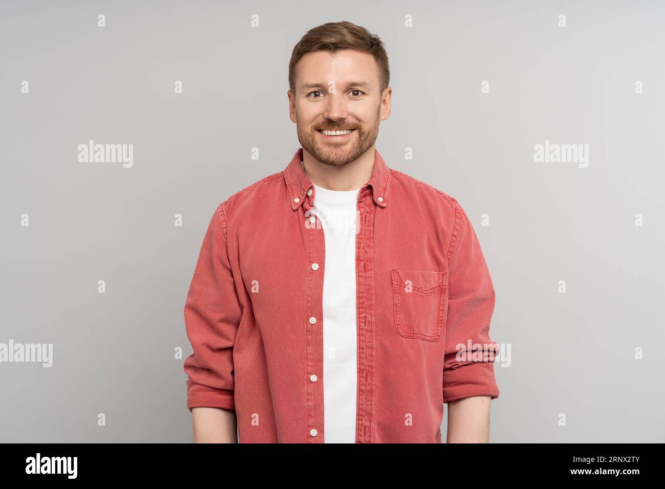 Pleased man smiling in high spirits looking confident at camera for ad ...