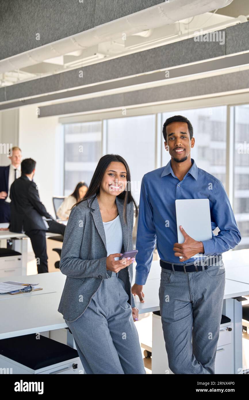 Smiling diverse colleagues standing in office meeting room, vertical portrait Stock Photo - Alamy