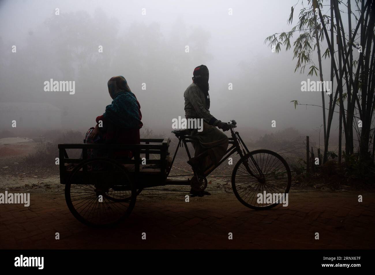 (180114) -- DHAKA, Jan. 14, 2018 -- A man rides a rickshaw puller ...