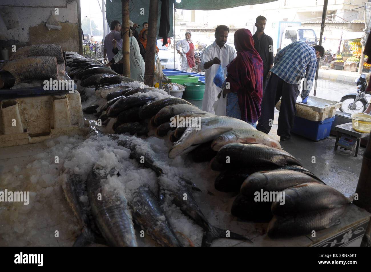 (180115) -- KARACHI, Jan. 15, 2018 -- People buy fish at a fish market ...