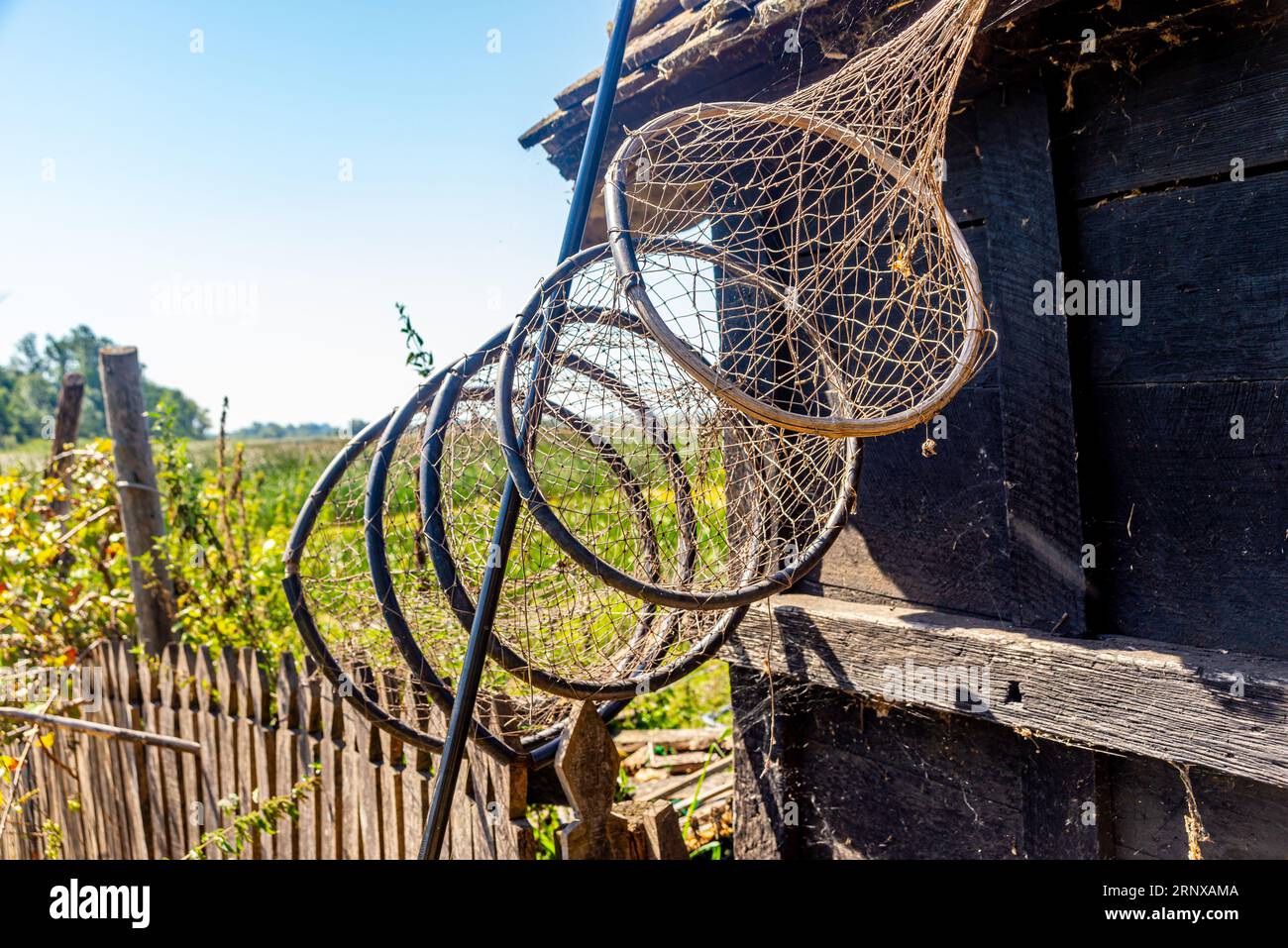Fishing tools hang on the roof of a log cabin in Zasavica nature ...
