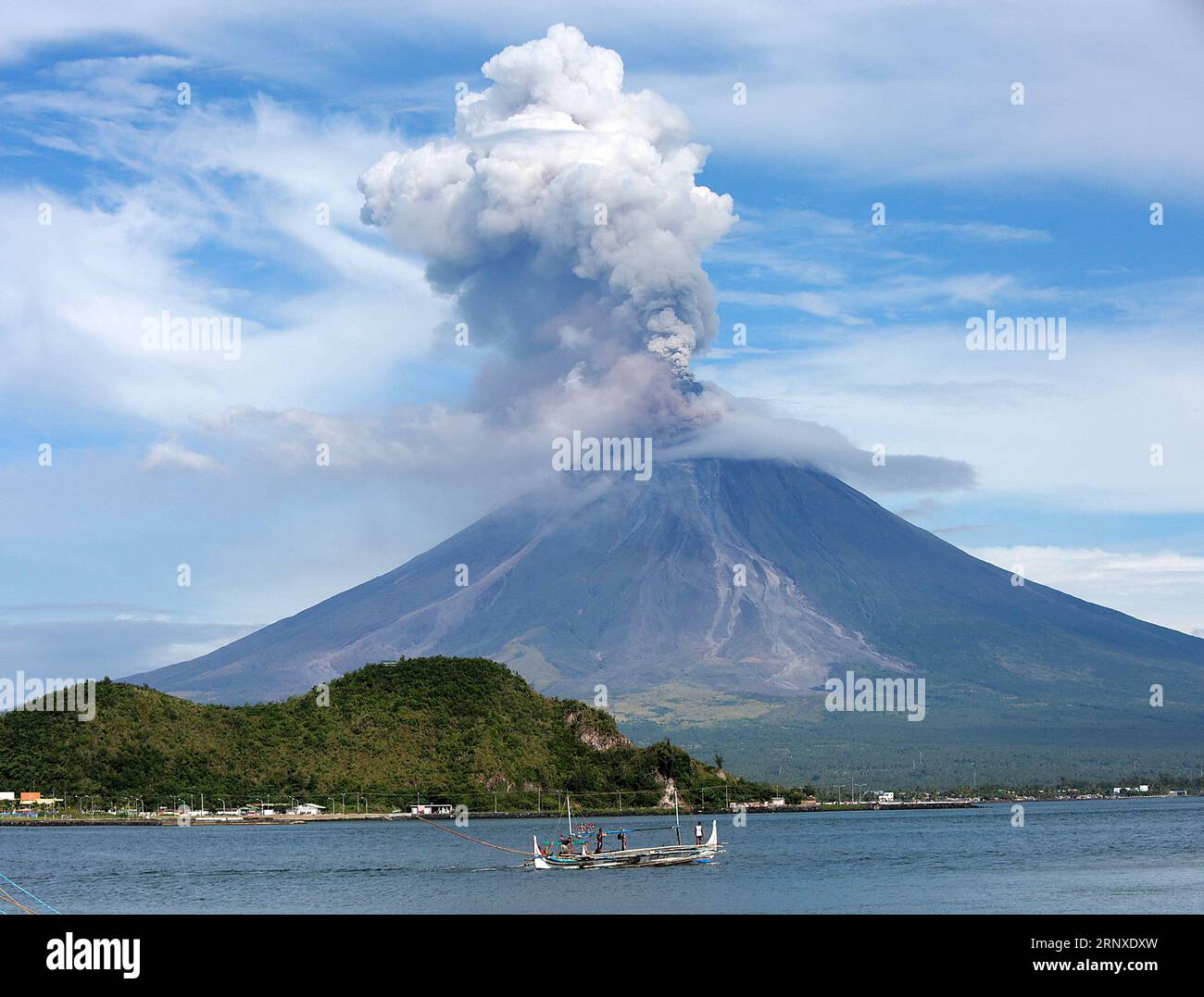 (180125) -- ALBAY, Jan. 25, 2018 -- A fishing boat sails as Mayon ...