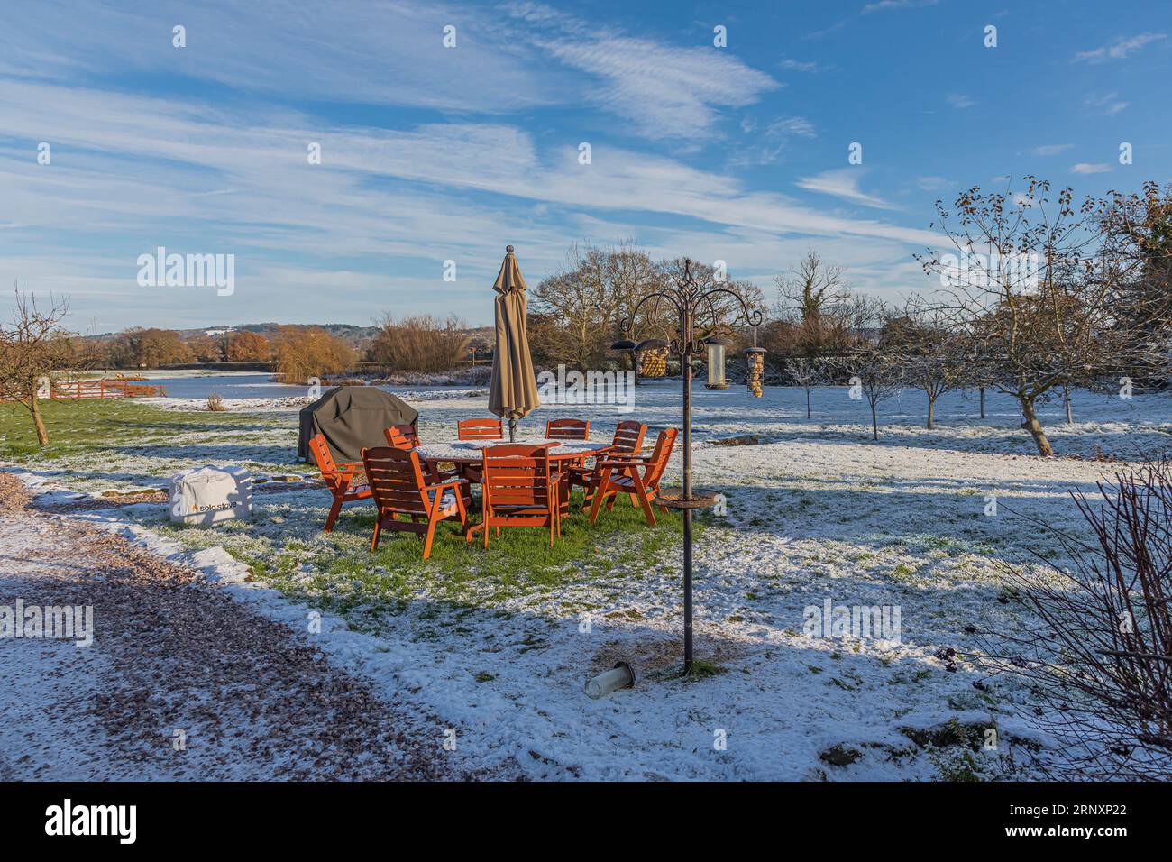 Umbrella and table outdoors in frosty winter scene with beautiful blue ...