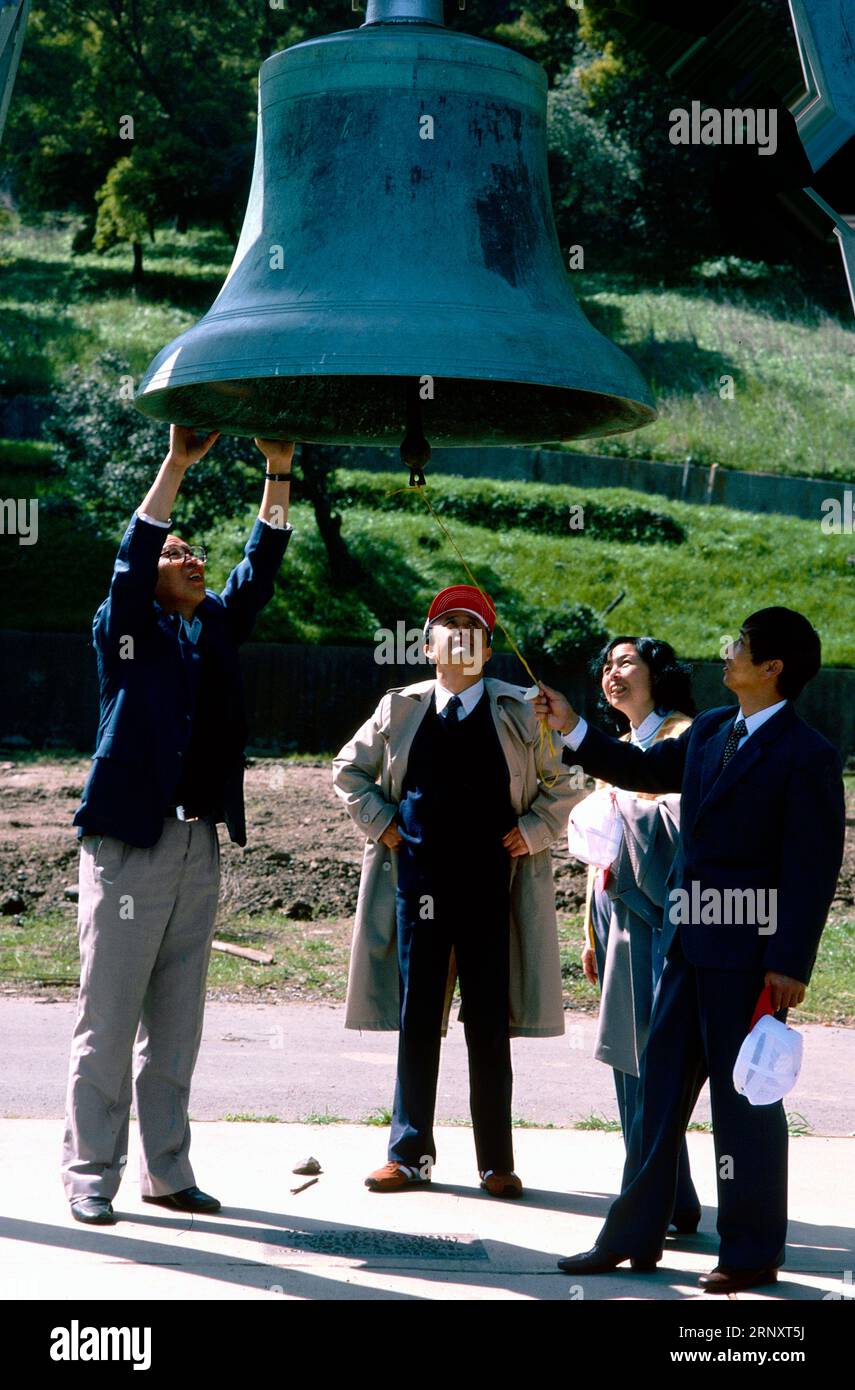 Chinese tourists ringing the memorial bell at the immigration facility ...