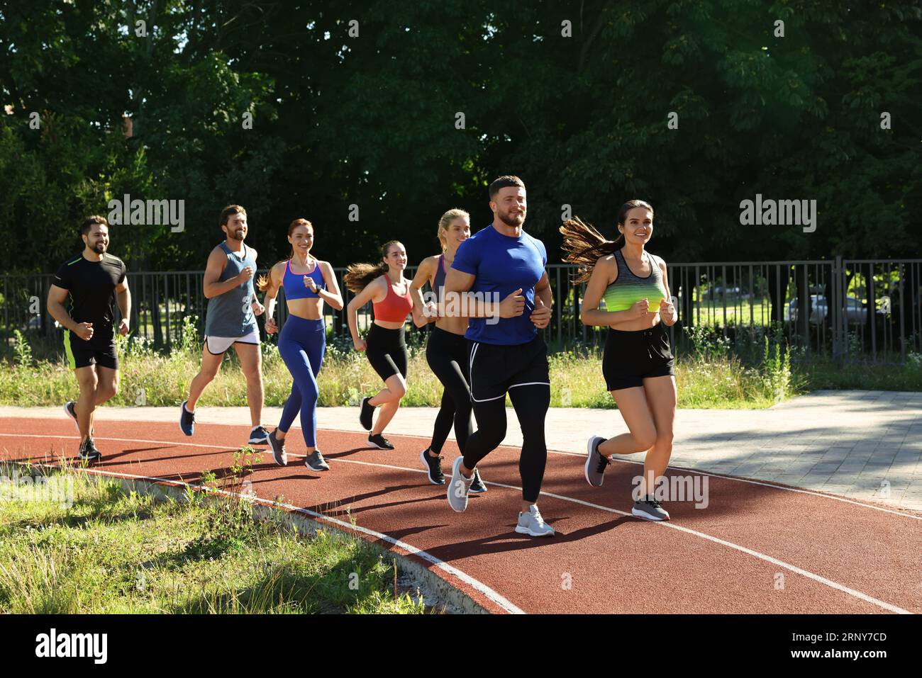 Group of people running at stadium on sunny day Stock Photo - Alamy