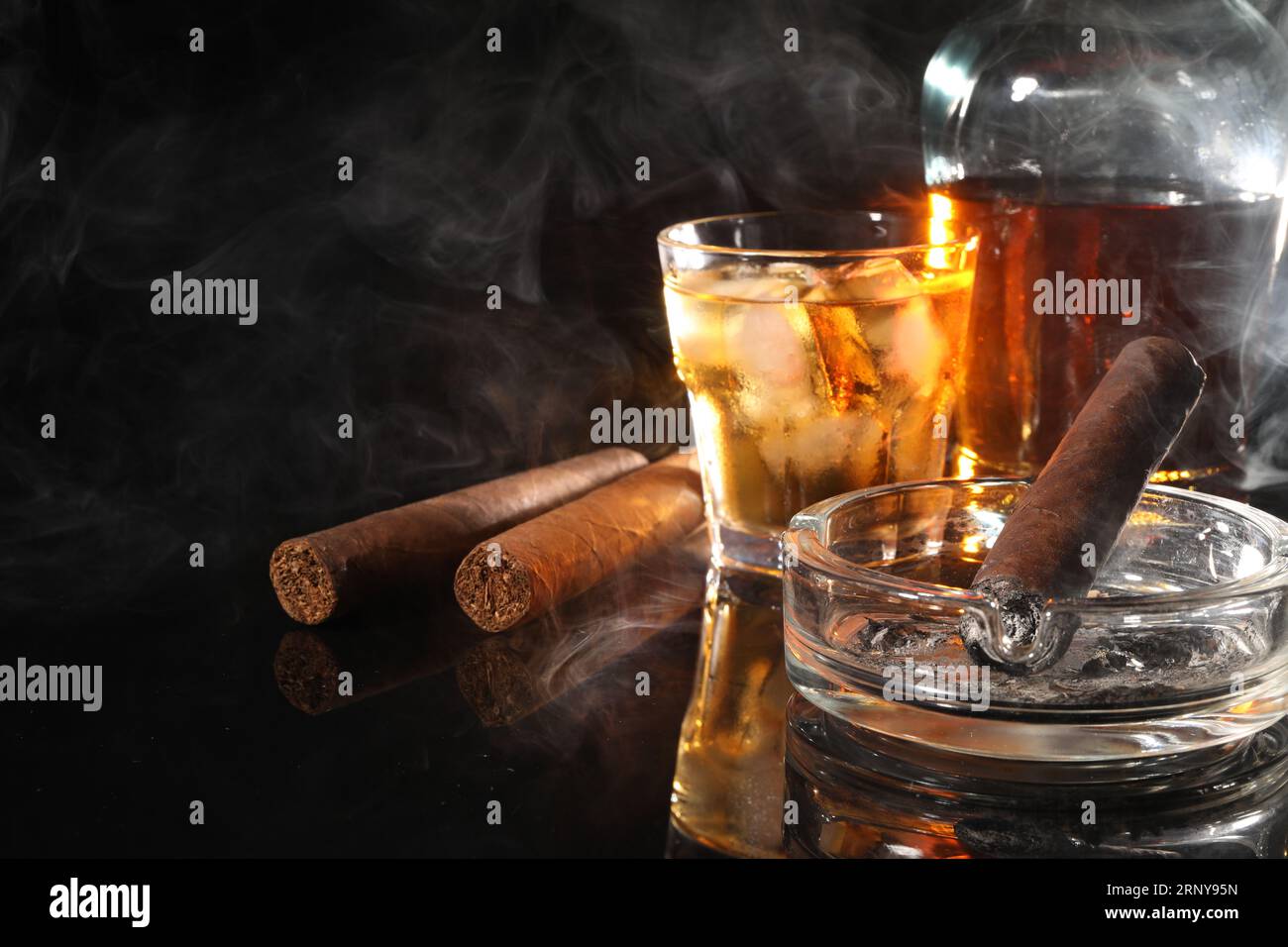 Smoldering cigar, ashtray and whiskey on black mirror surface Stock ...