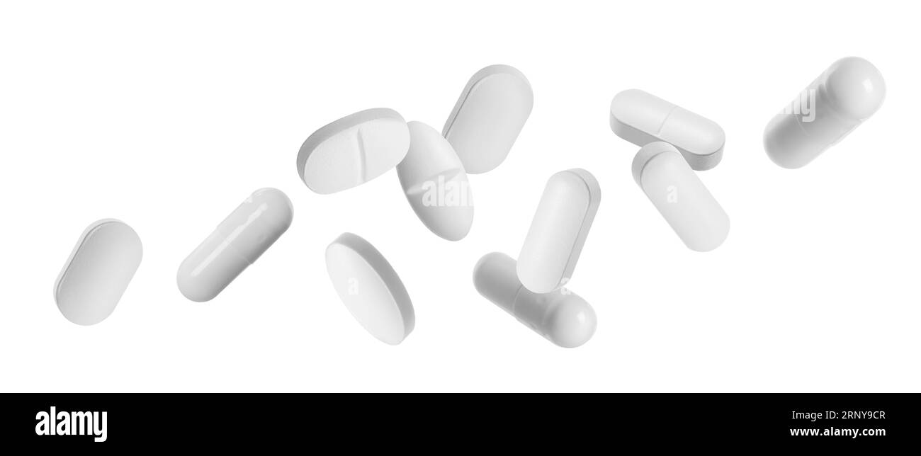 Many different pills falling on white background Stock Photo - Alamy