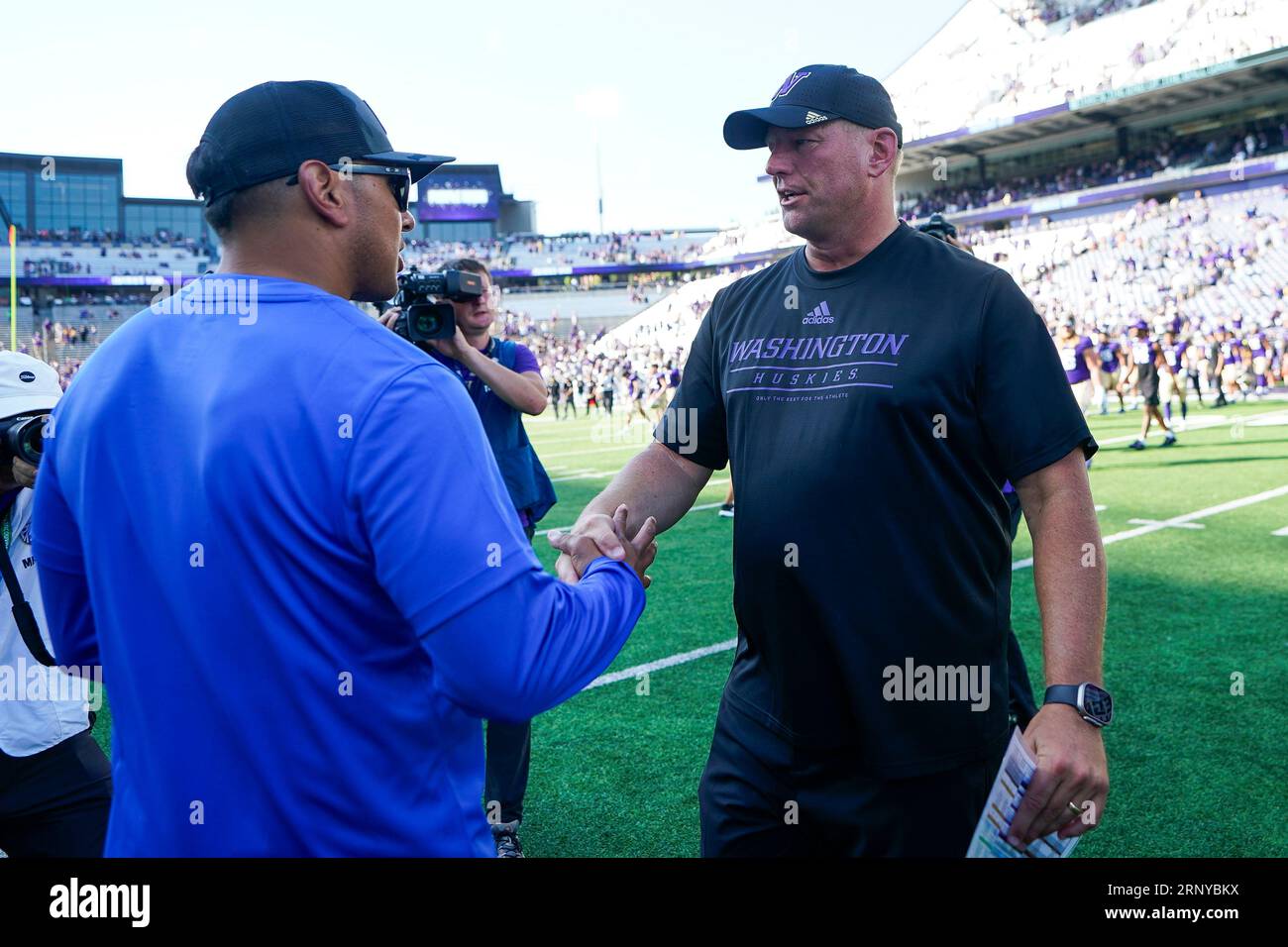 Boise State coach Andy Avalos, left, greets Washington coach Kalen ...
