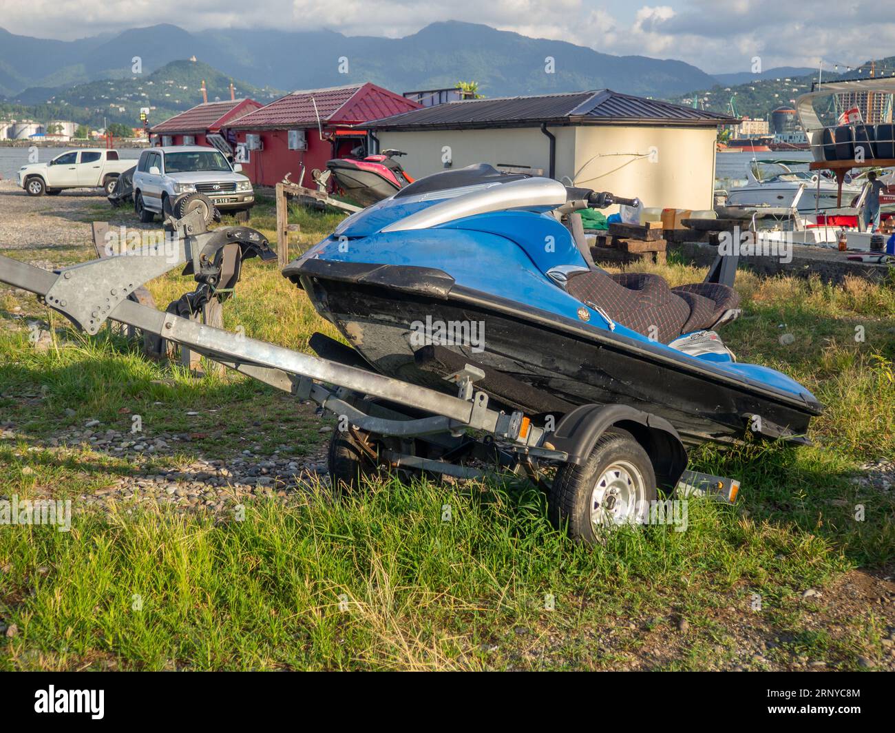 Broken jet ski on a trailer. Abandoned vehicle. Water bike on the shore ...