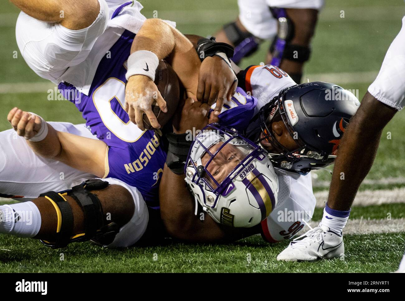 James Madison quarterback Brett Griffis (10) gets upended by Bucknell ...