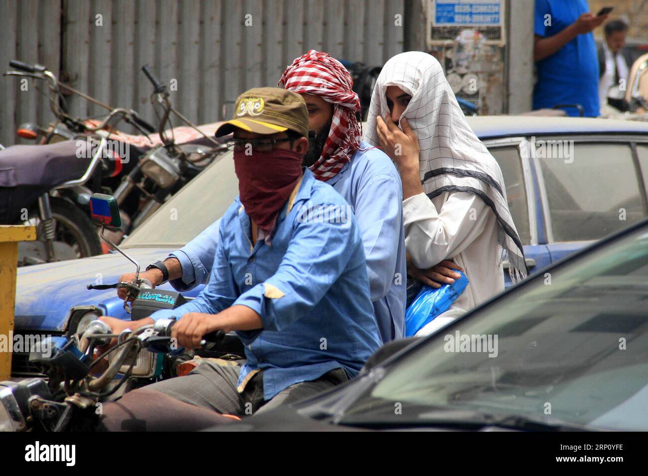 (180530) -- KARACHI, May 30, 2018 -- Bike riders cover their faces ...