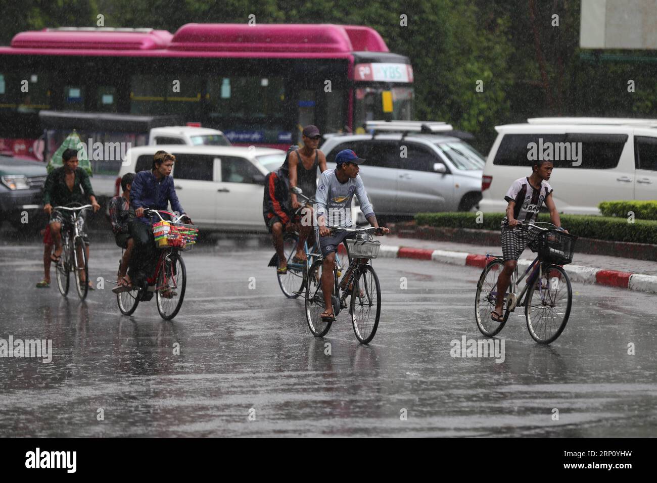 (180530) -- YANGON, May 30, 2018 -- People ride bicycles in the rain in ...
