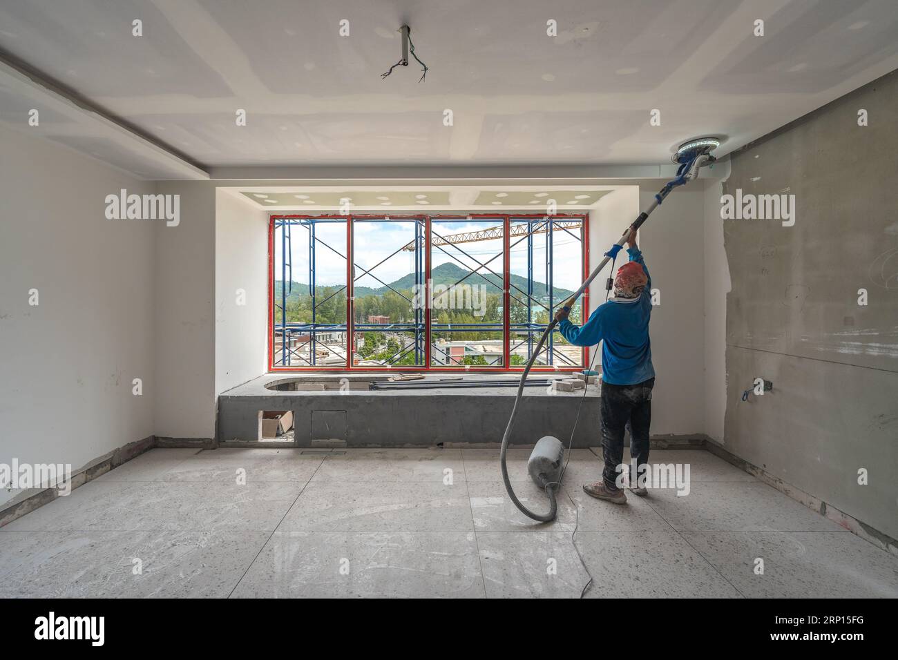 Laborer performing and polishing sand and cement screed wall on the ...