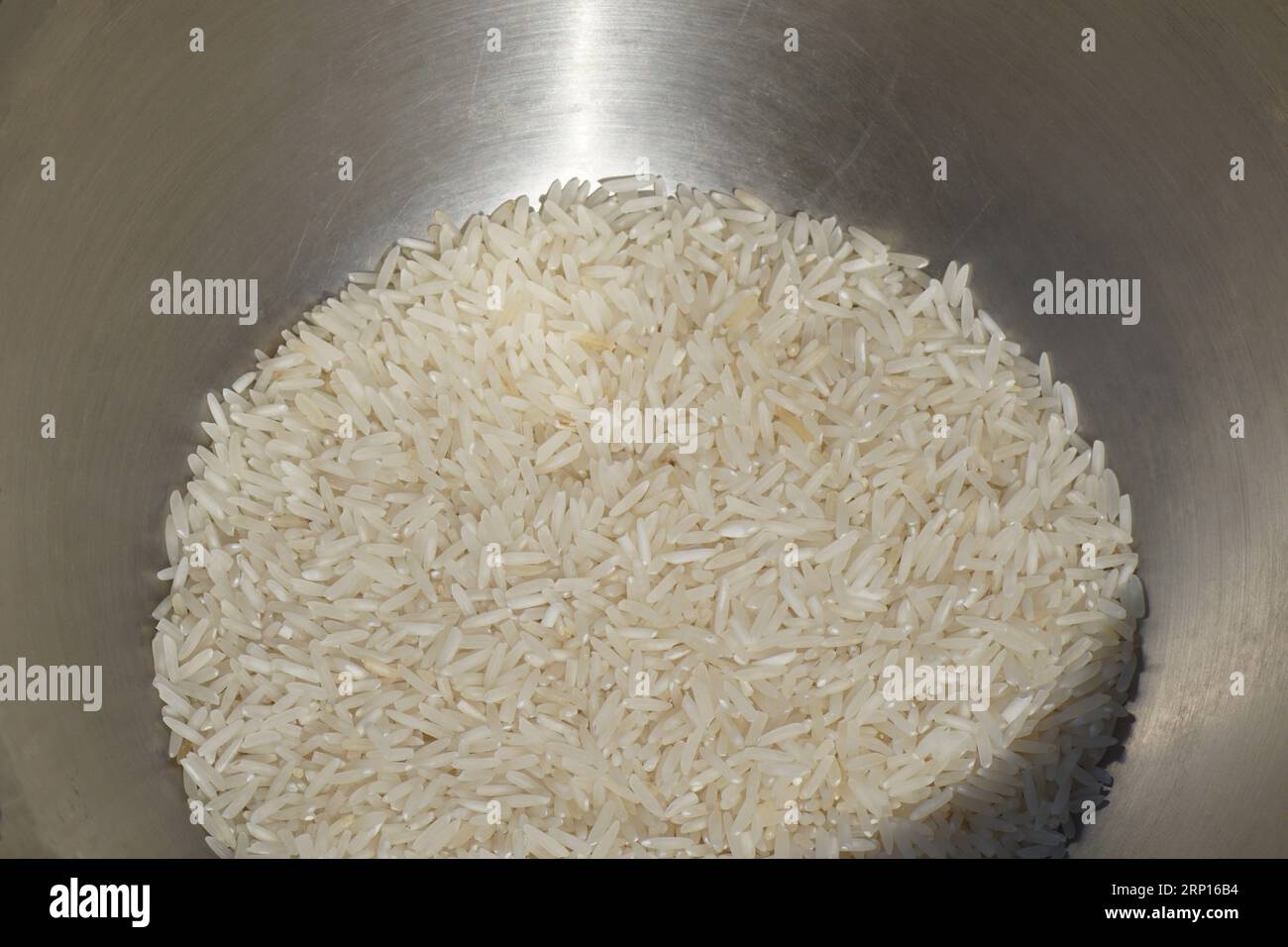 Closeup uncooked rice grains in an aluminum dish Stock Photo - Alamy