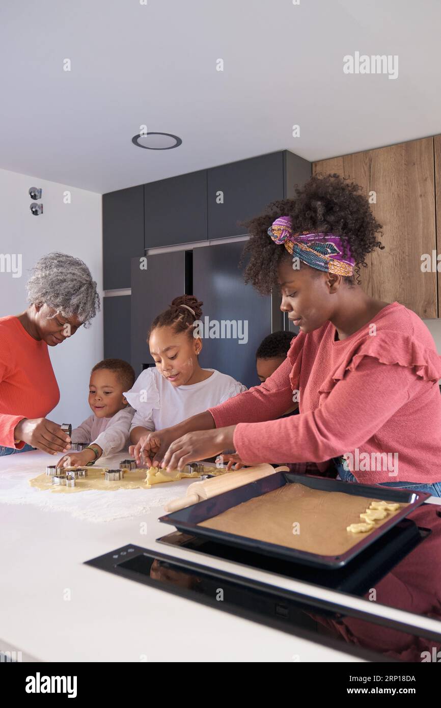 African family cutting cookie shapes in a cookie dough in the kitchen ...