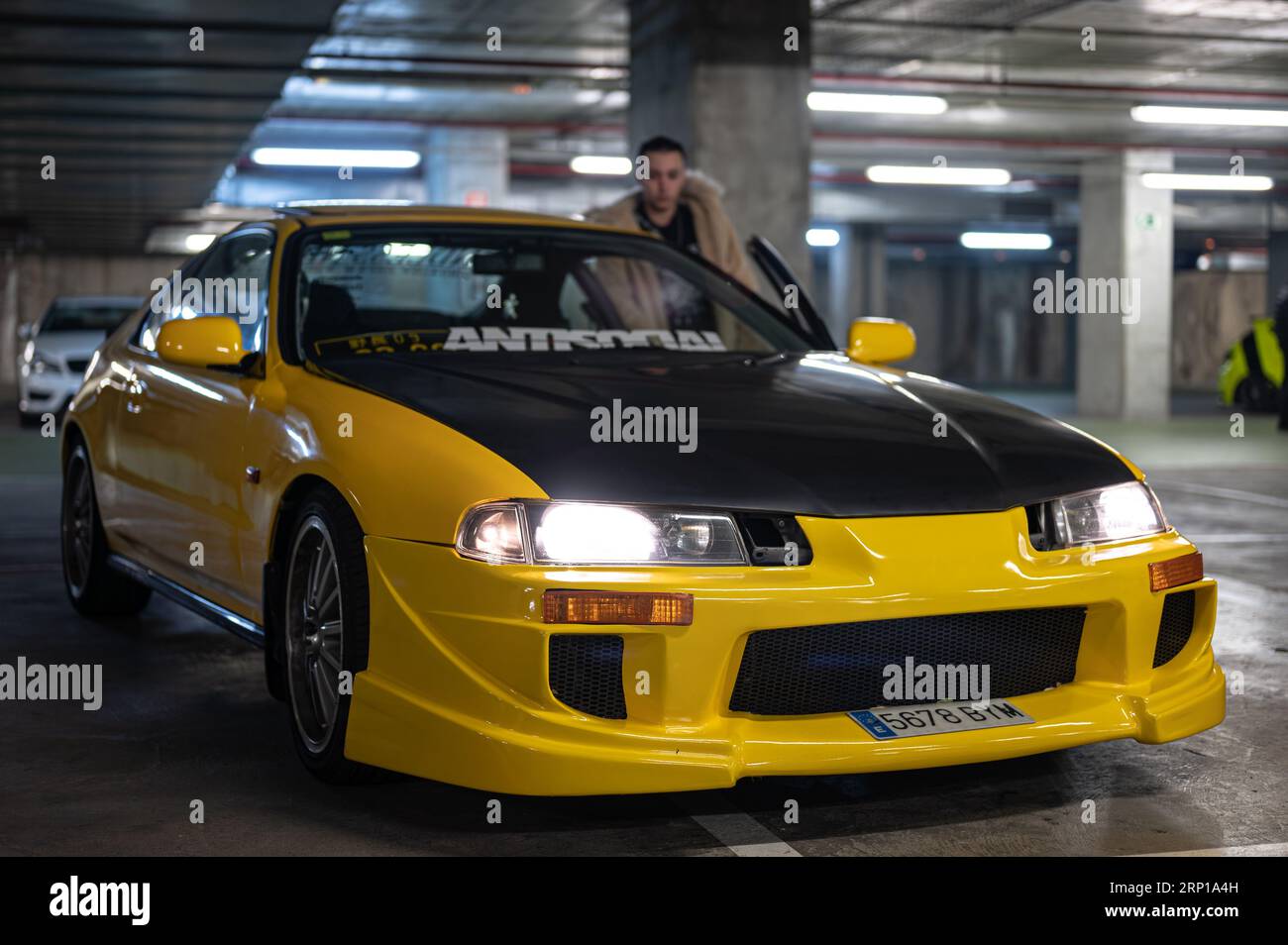 A young guy getting out of his Honda Prelude modified yellow Stock ...