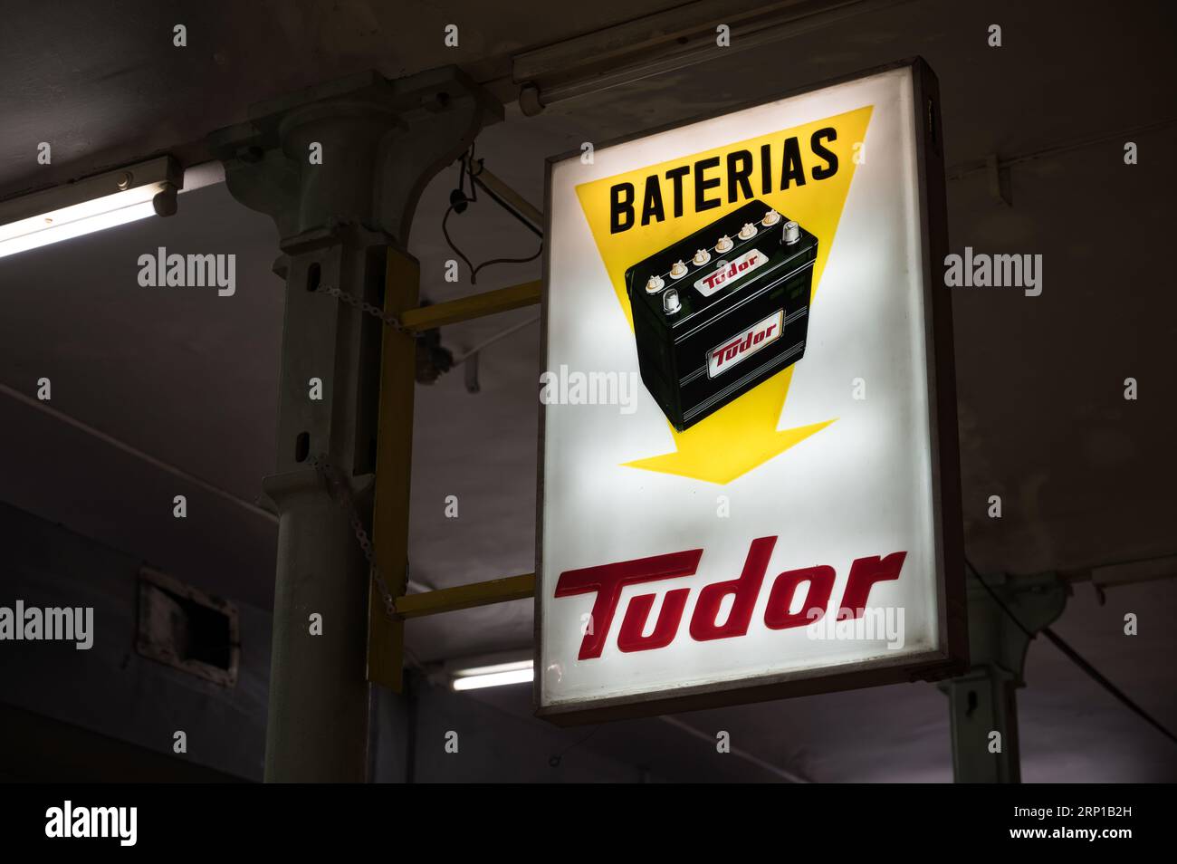 A closeup of an old illuminated sign of Tudor batteries for the car in ...