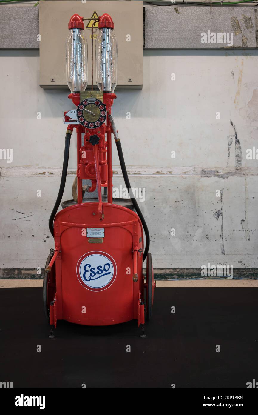 A closeup of a barrel of gasoline on a cart with wheels and a manual ...