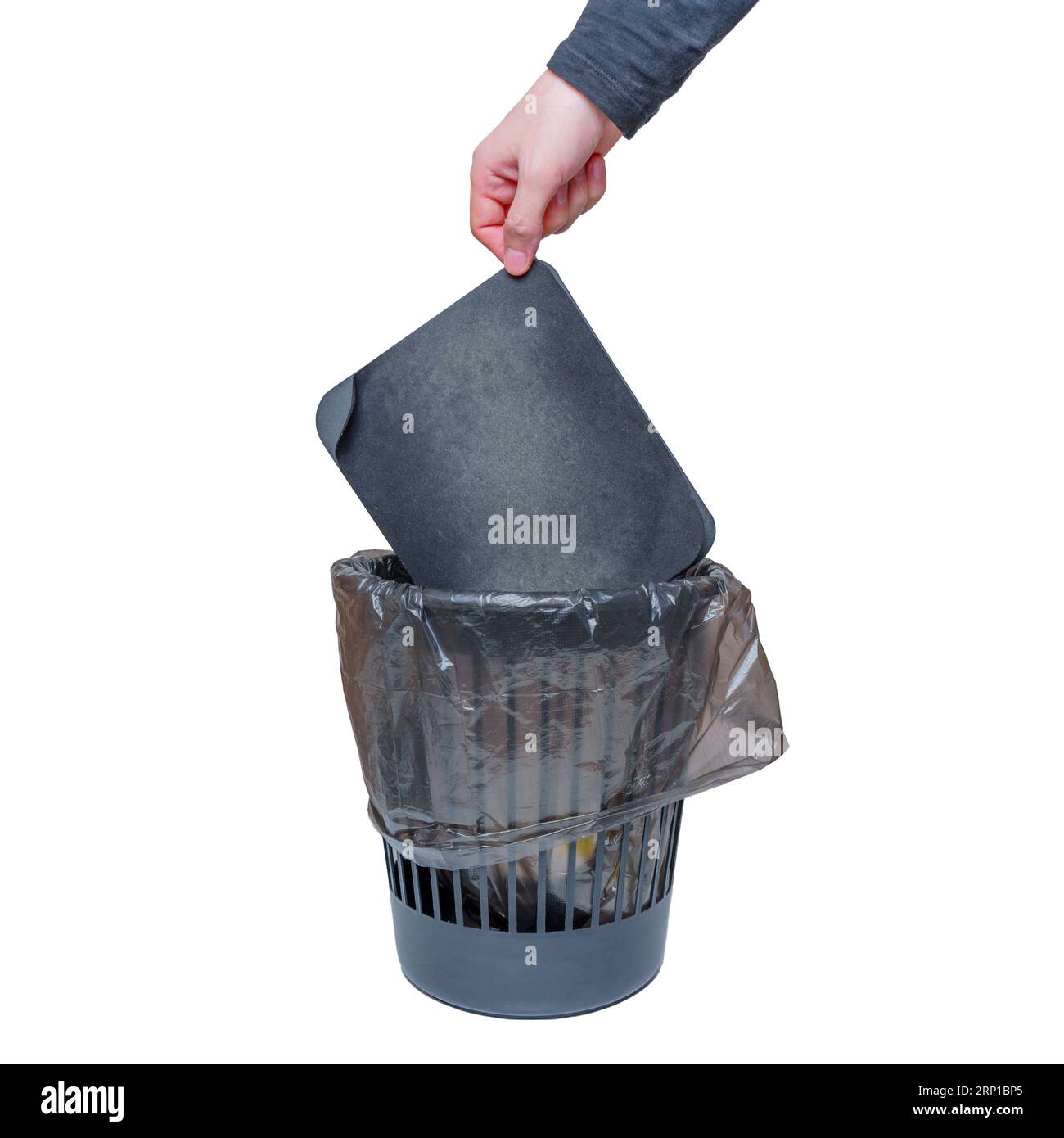 Close-up view of a hand tossing a worn and well-used mouse pad into a ...