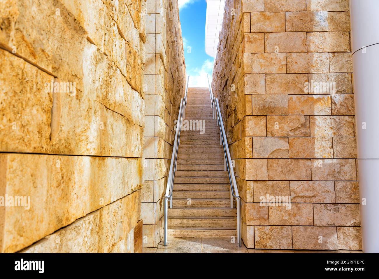 Ascending steps between two walls leading toward the vibrant blue sky ...