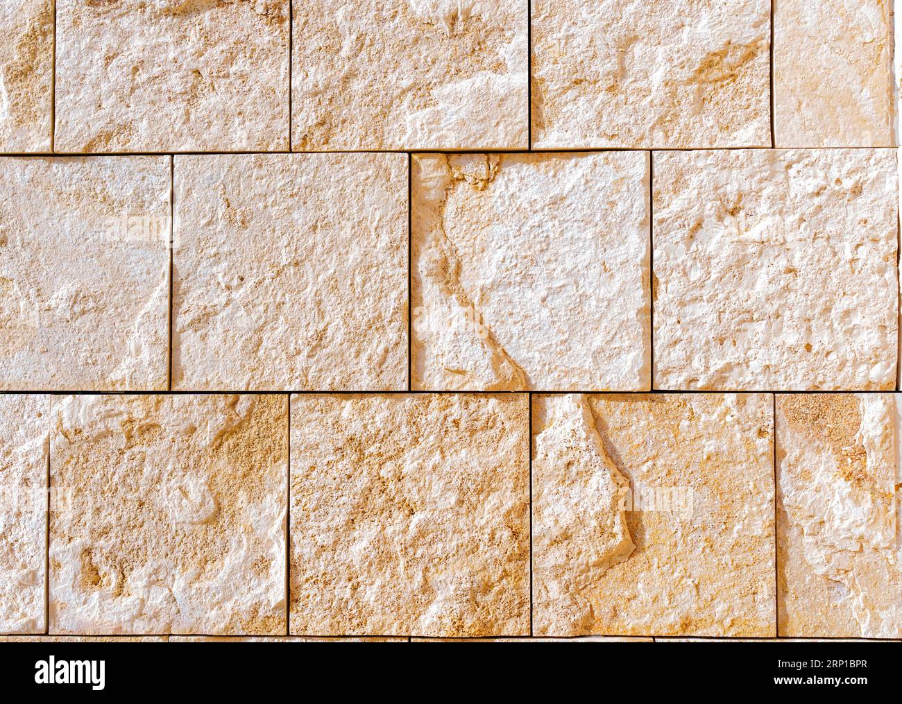 Natural background made from sand-colored stone wall with a square ...