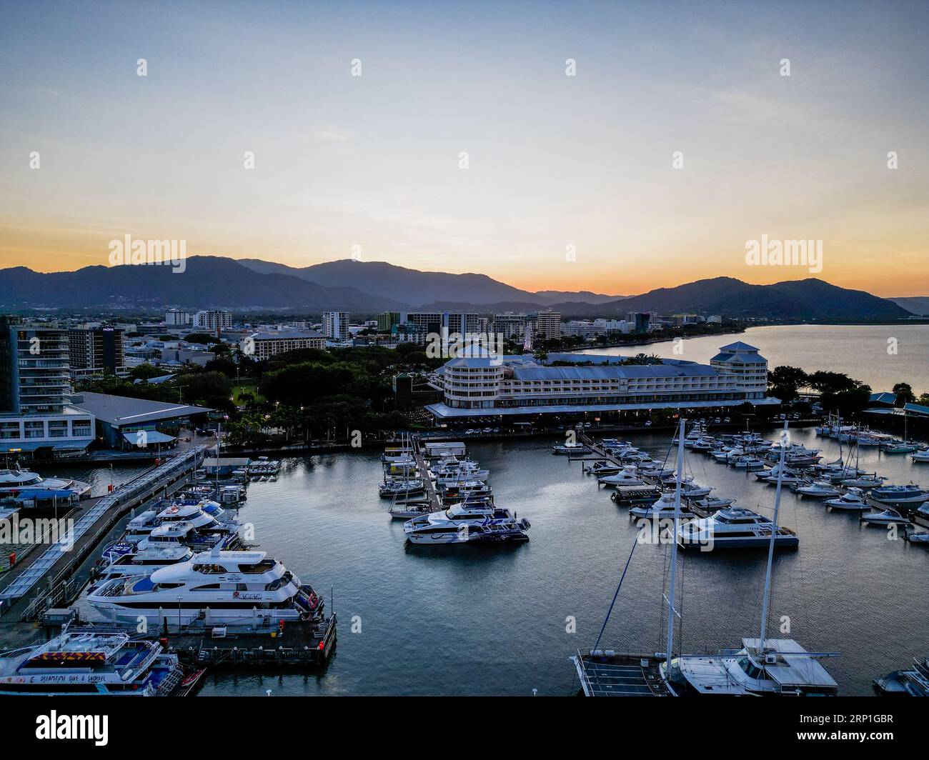 Sunset drone shot at Cairns Marina and Esplanade with orange sky and a ...
