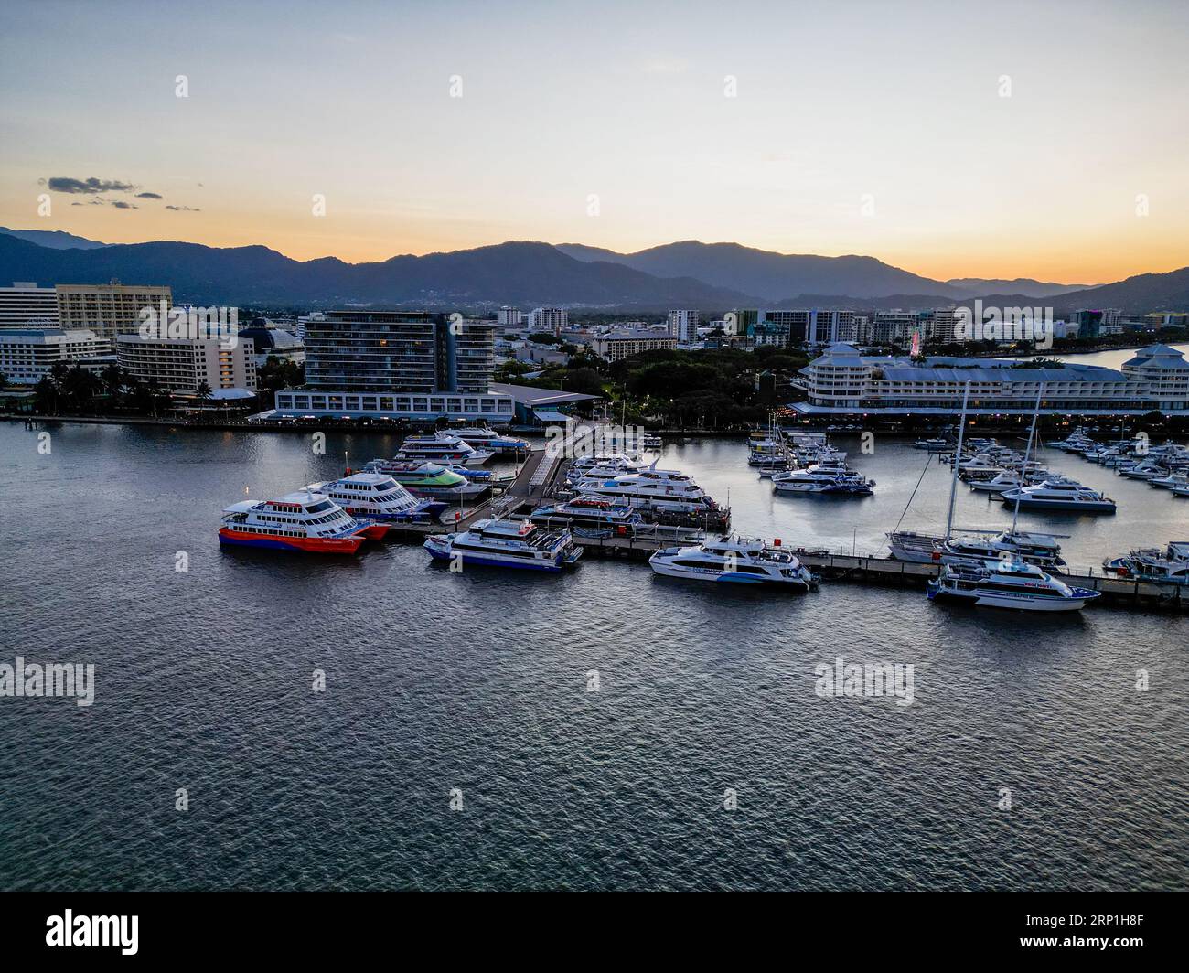 Sunset drone shot at Cairns Marina and Esplanade with orange sky and a ...