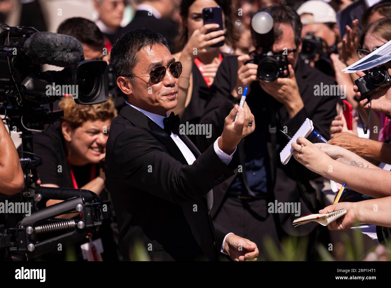 Tony Leung interacts with fans upon arrival for the Golden Lion for ...