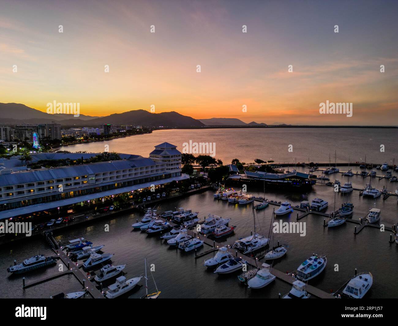Sunset drone shot at Cairns Marina and Esplanade with orange sky and a ...