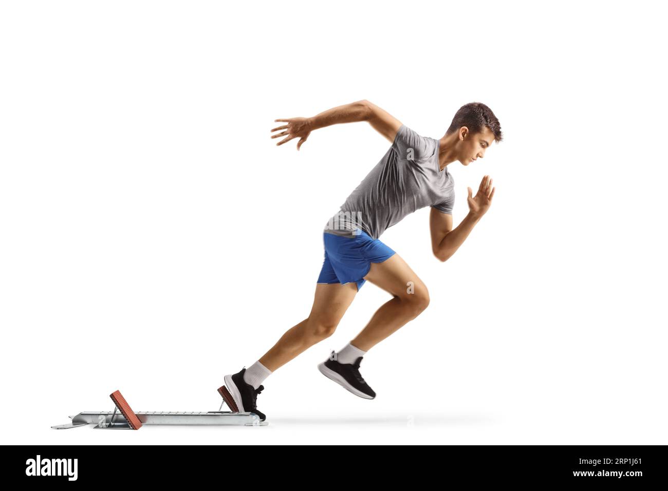 Full length profile shot of a guy beginning a race from start blocks ...