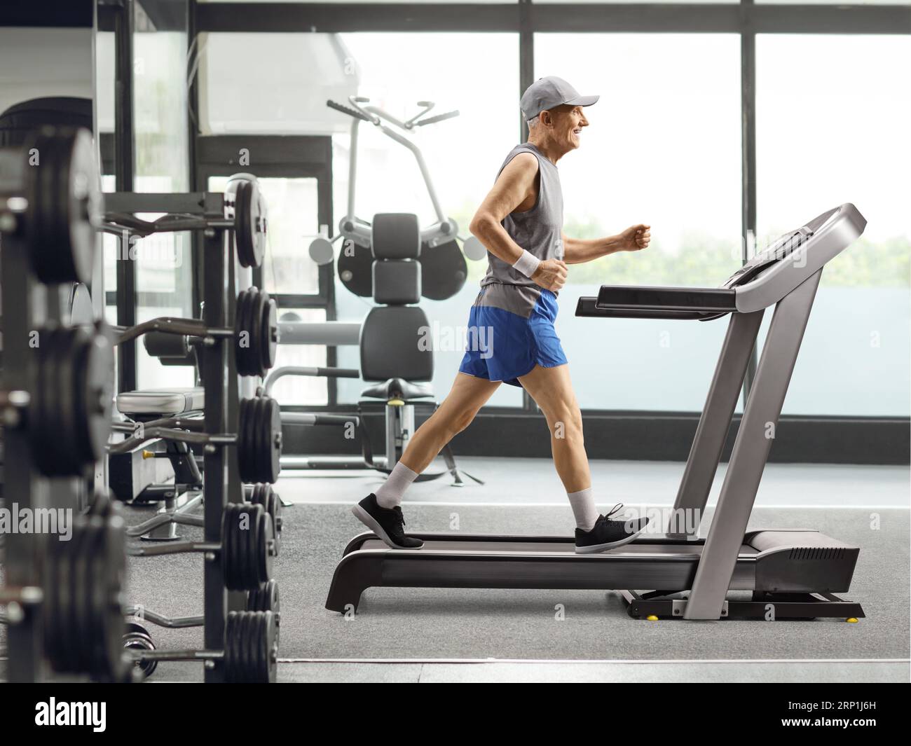 Full length profile shot of an active senior man walking on a treadmill ...