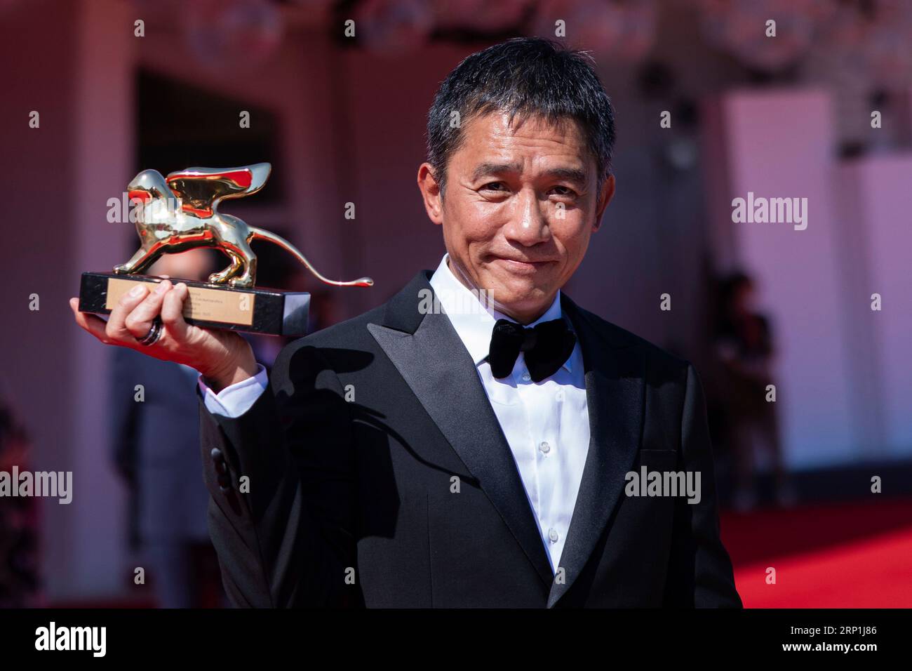Tony Leung Chiu-wai poses for photographers with the Golden Lion for ...