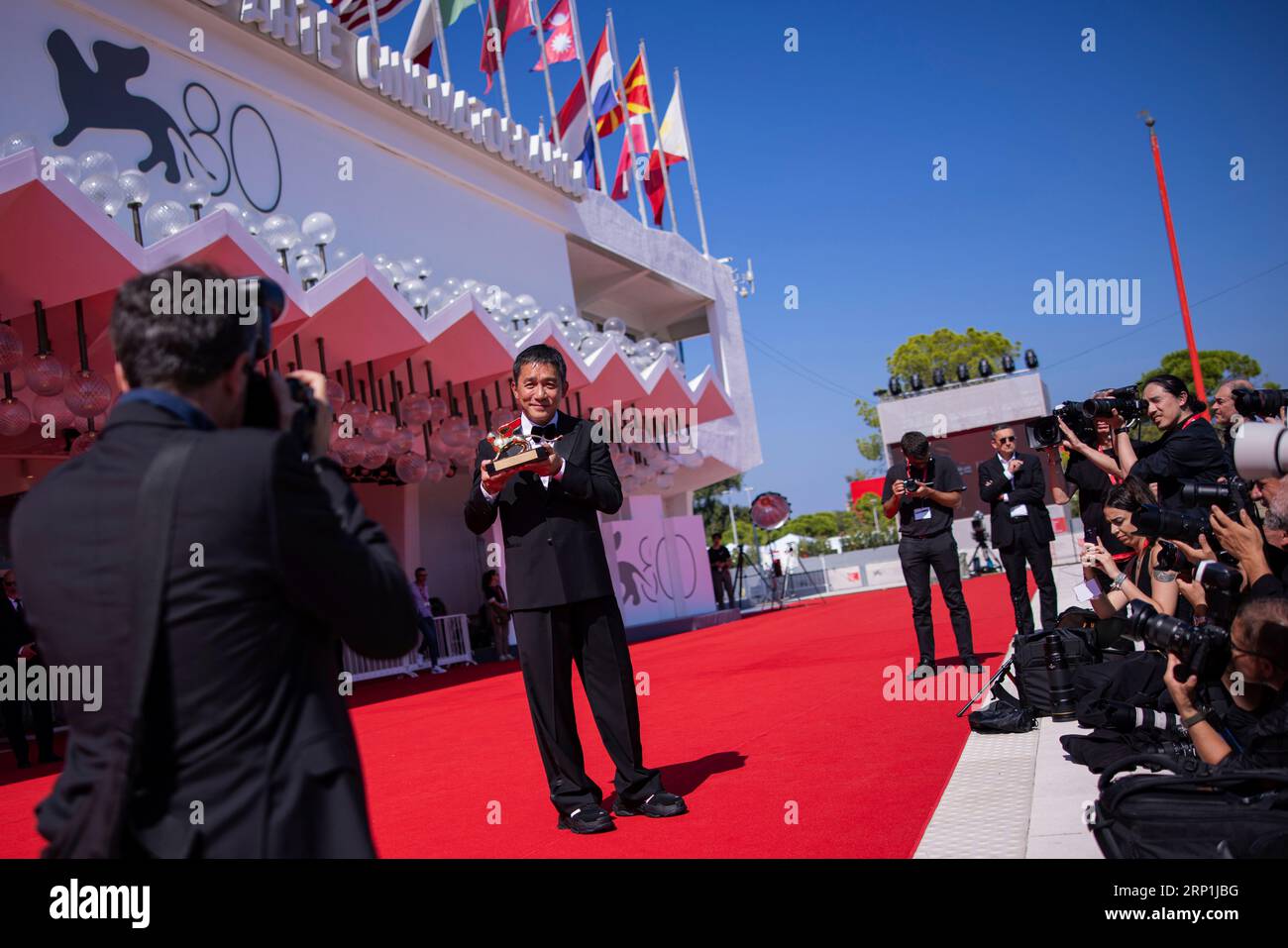 Tony Leung Chiu-wai poses for photographers with the Golden Lion for ...