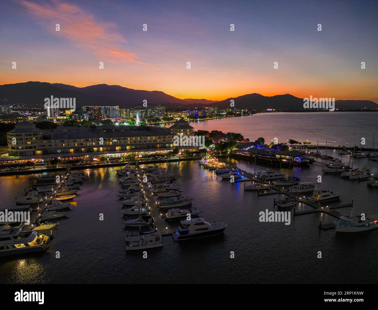 Night time sunset drone shot at Cairns Marina and Esplanade with orange ...