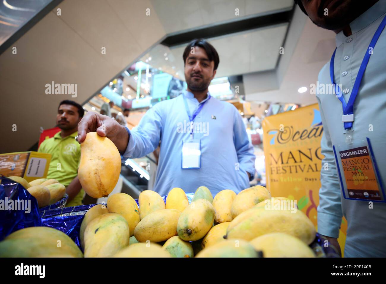 (180803) -- ISLAMABAD, Aug. 3, 2018 -- A vendor holds a mango at a ...