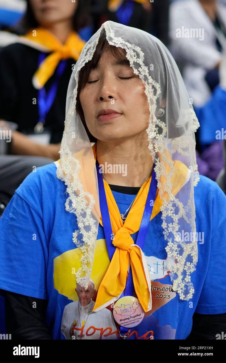A faithful follows the Mass presided over by Pope Francis and ...