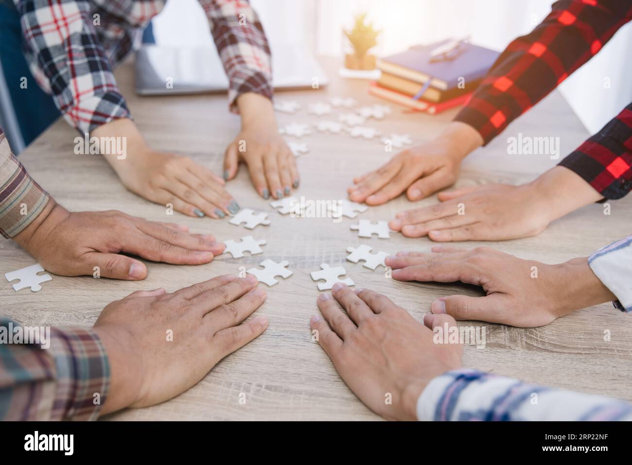 Group of business people putting their hands on a table with jigsaw ...