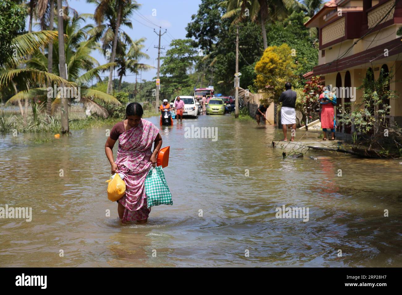 (180824) -- KERALA, Aug. 24, 2018 -- People wade through flood water in ...
