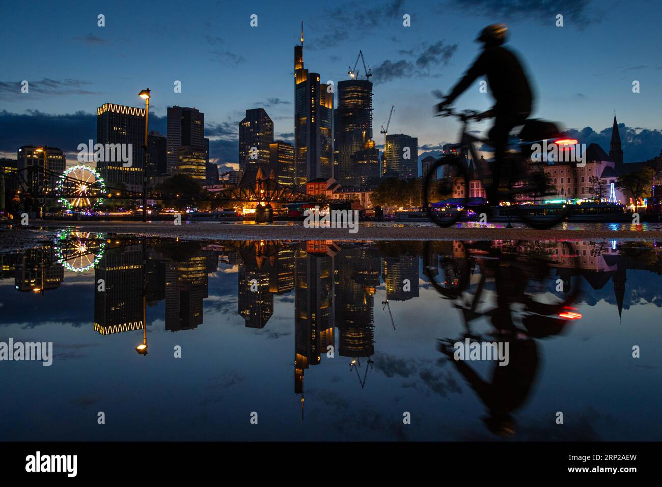 The colourful lights of the Mainfest are reflected in a puddle. The ...