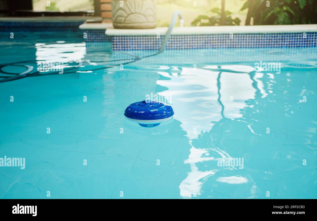 Chlorine dispenser in a beautiful swimming pool. A chlorine float in a ...