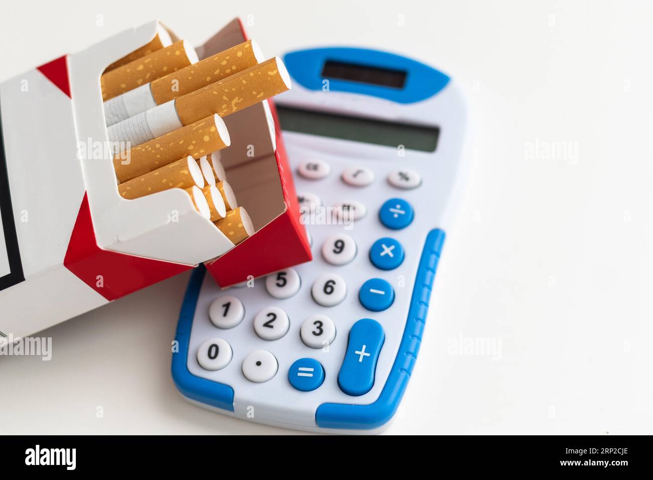 closeup on calculator with digits on display, cigarette pack and ...