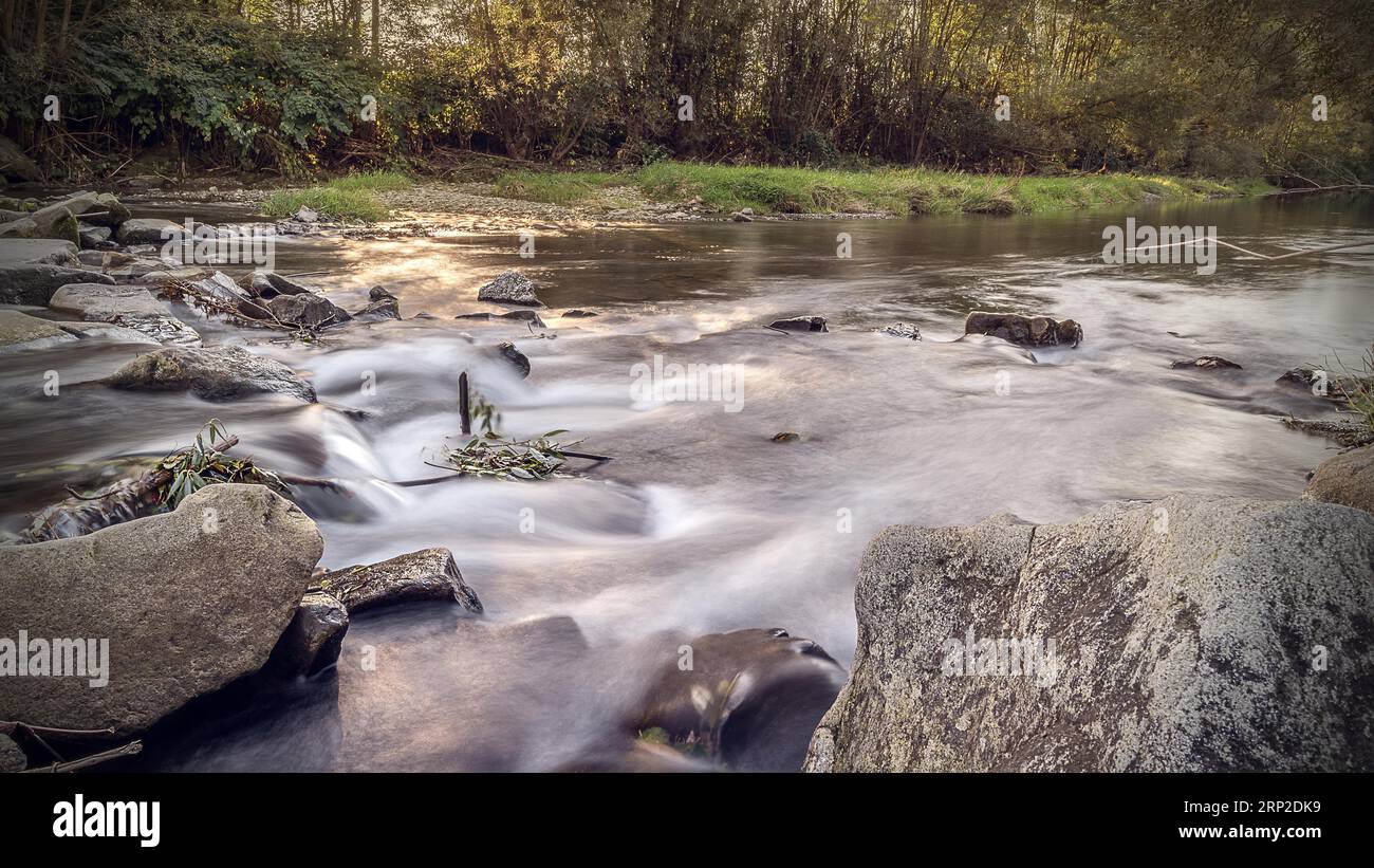 Long exposure of the mountain river in the rays of the setting sun ...